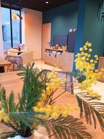Um interior moderno com área de refeições, cozinha e uma grande janela.
