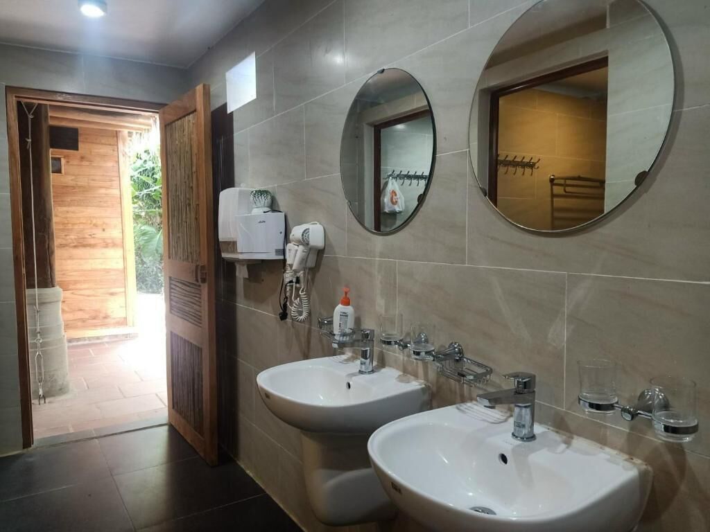 Uma casa de banho moderna com duas pias, um espelho e um porta-toalhas.