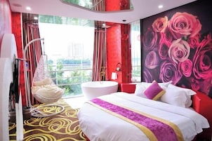 Quarto moderno com cama grande, cadeira suspensa, banheira e vista para a cidade.