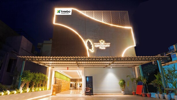 Um edifício com um grande letreiro iluminado que diz 'Treebo Kingsbury Fiesta'.
