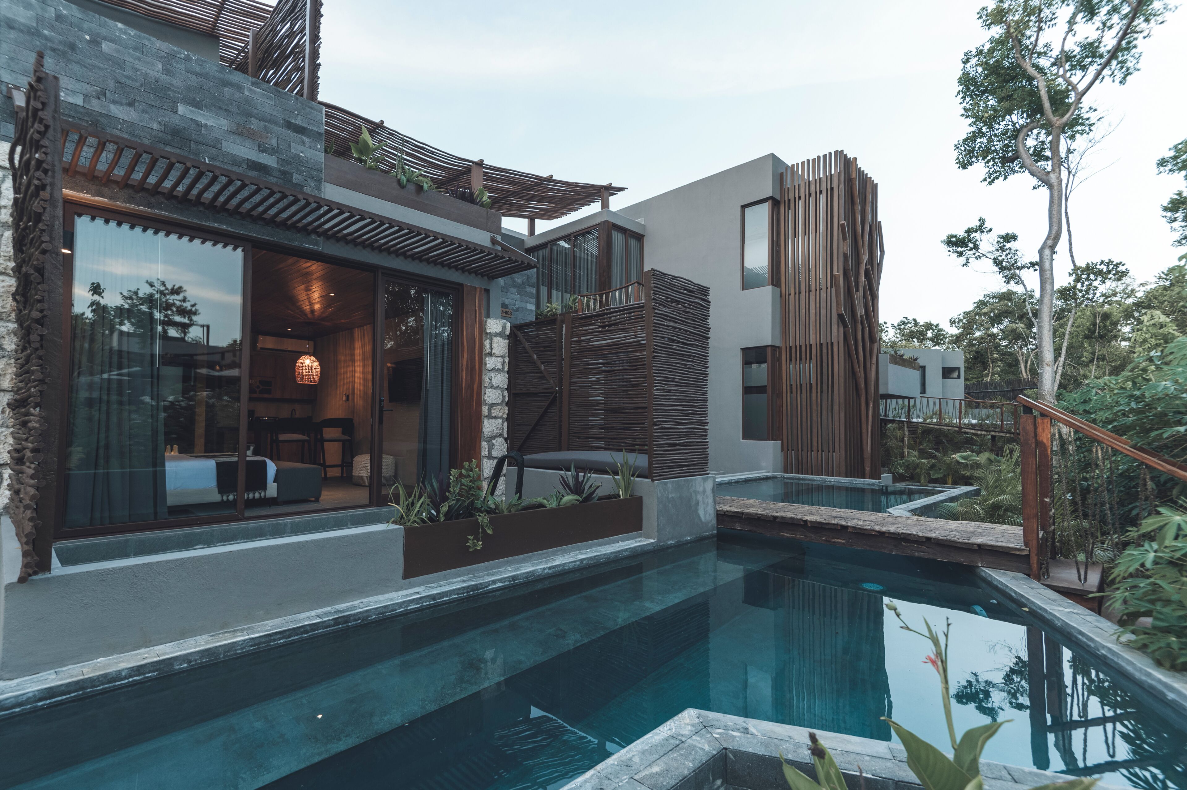 Uma casa moderna com piscina, deck de madeira e área de estar ao ar livre.