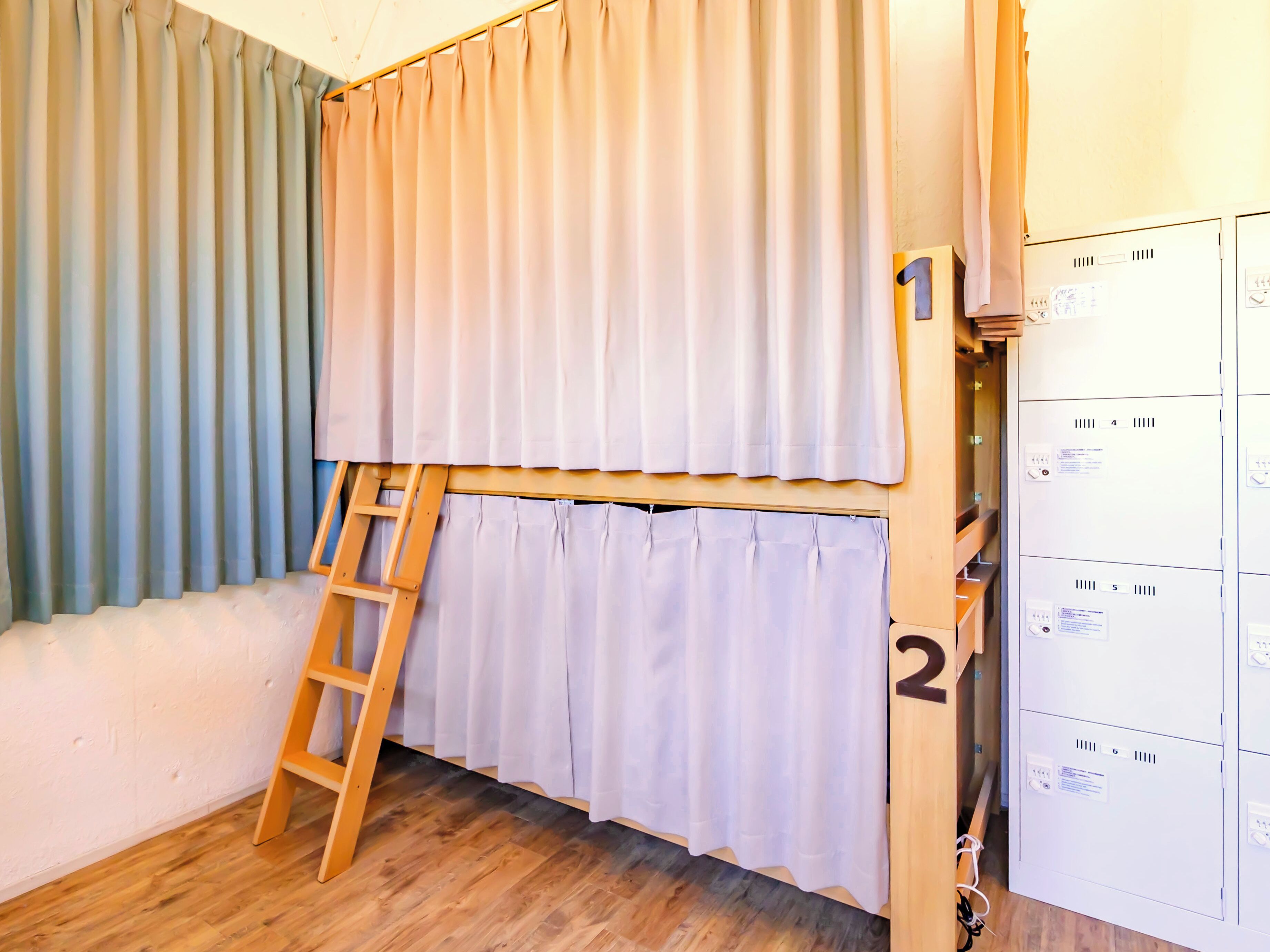 Um quarto em dormitório com beliches, uma escada de madeira e armários.