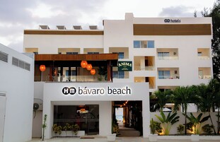 Um hotel com design moderno, com um restaurante chamado "ANIMA" e vista para a praia.