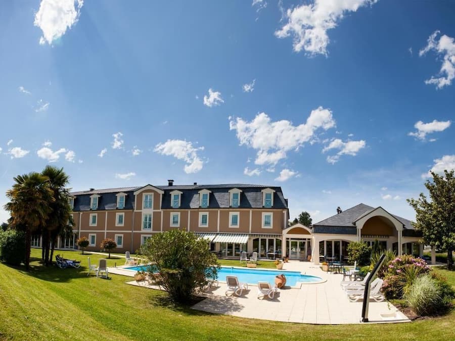 Um hotel com piscina, área de estar externa e gramado bem cuidado.