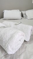 Cama com almofadas brancas e manta felpuda branca.