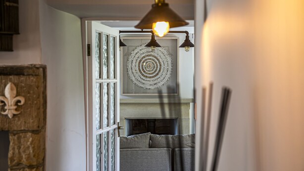 Um quarto aconchegante com lareira, um painel decorativo e uma cama com almofadas.