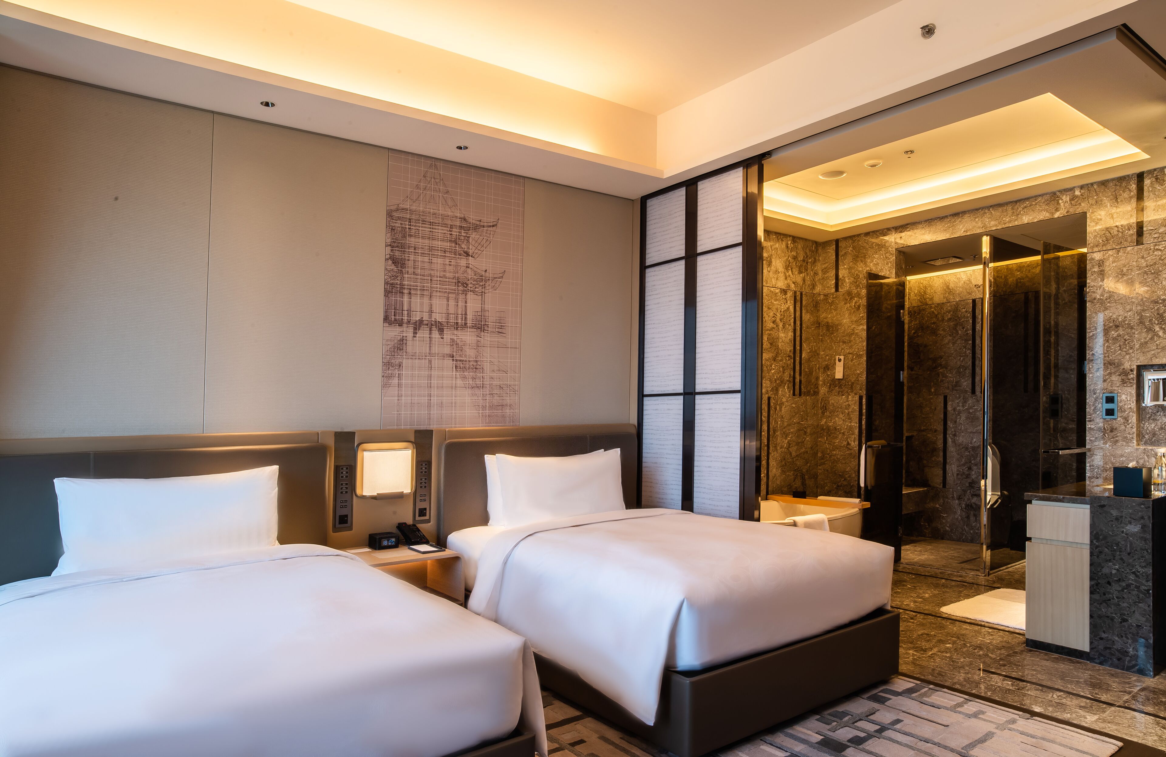 Quarto de hotel com duas camas, um espelho grande, closet espaçoso e banheiro privativo com chuveiro e toucador.