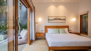 Quarto com cama de madeira, mesa de cabeceira e uma grande janela com vista para o verde.