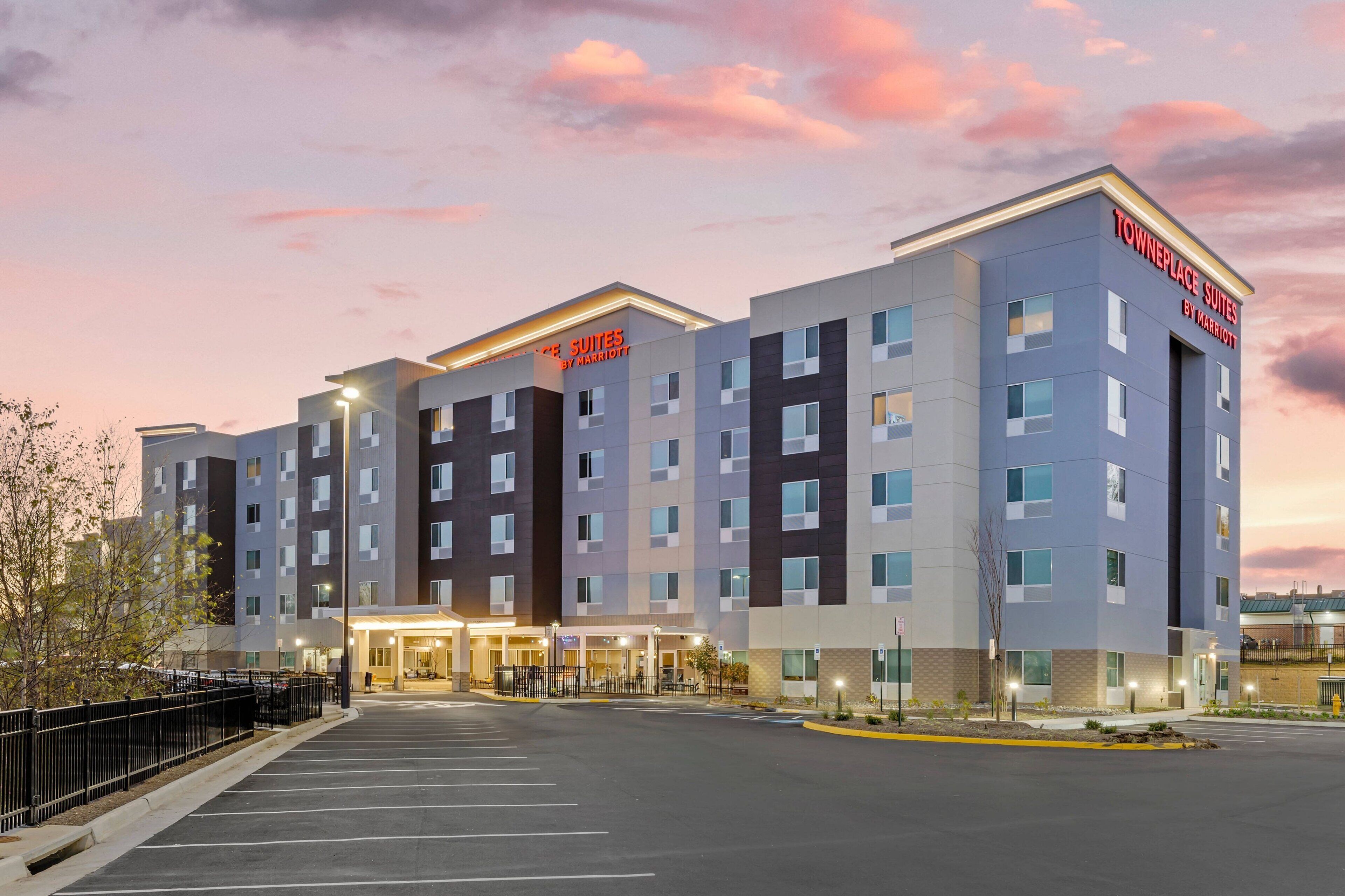 Um hotel de vários andares com design moderno, exibindo uma placa chamativa para 'TownePlace Suites by Marriott'.