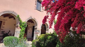 Um edifício com portas em arco e fachada rosa.