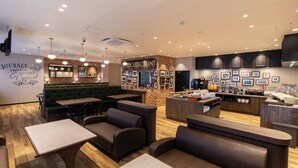Um restaurante moderno com parede de tijolos, quadros decorativos e um espaço de bar.