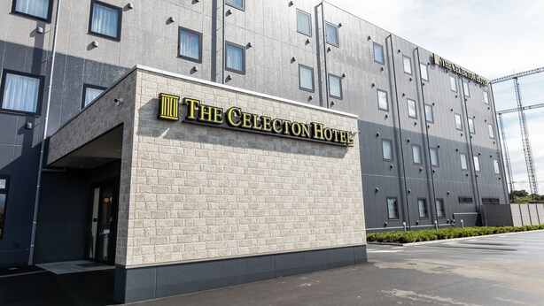 Um hotel com fachada moderna, exibindo uma placa chamativa para 
