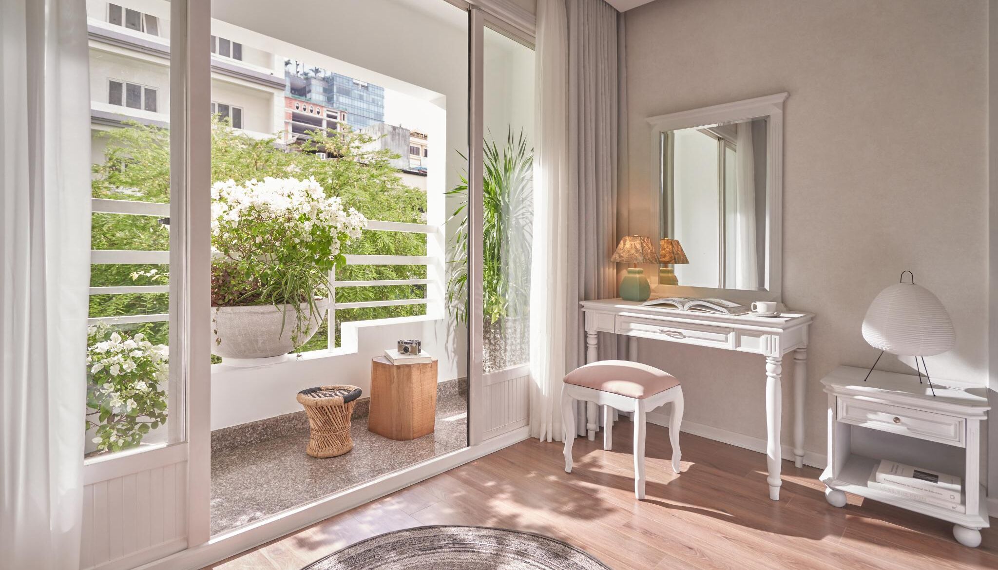 Um banheiro moderno com toucador, espelho e vista para o verde lá fora.
