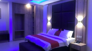 Quarto moderno com cama grande, guarda-roupa embutido e iluminação ambiente.