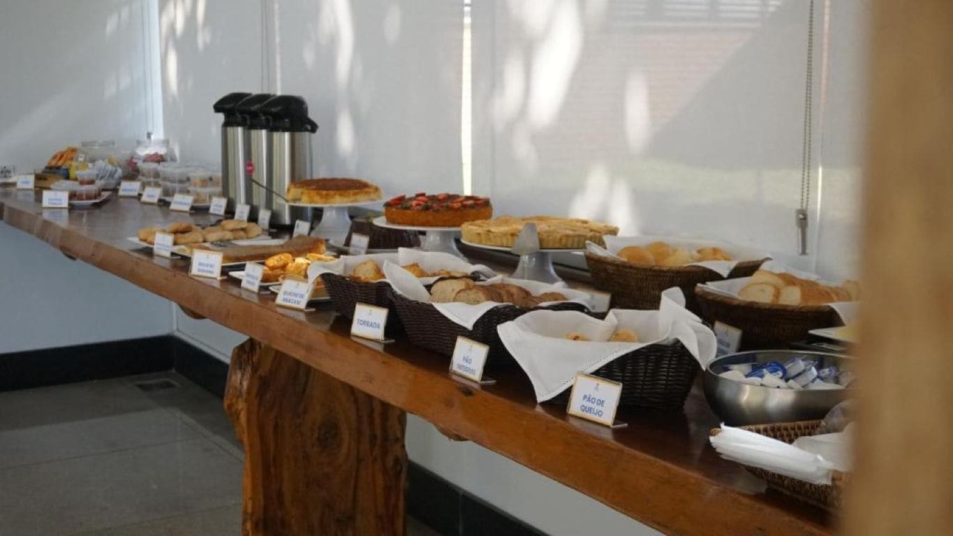 Mesa de buffet com diversos alimentos e cestas identificadas.