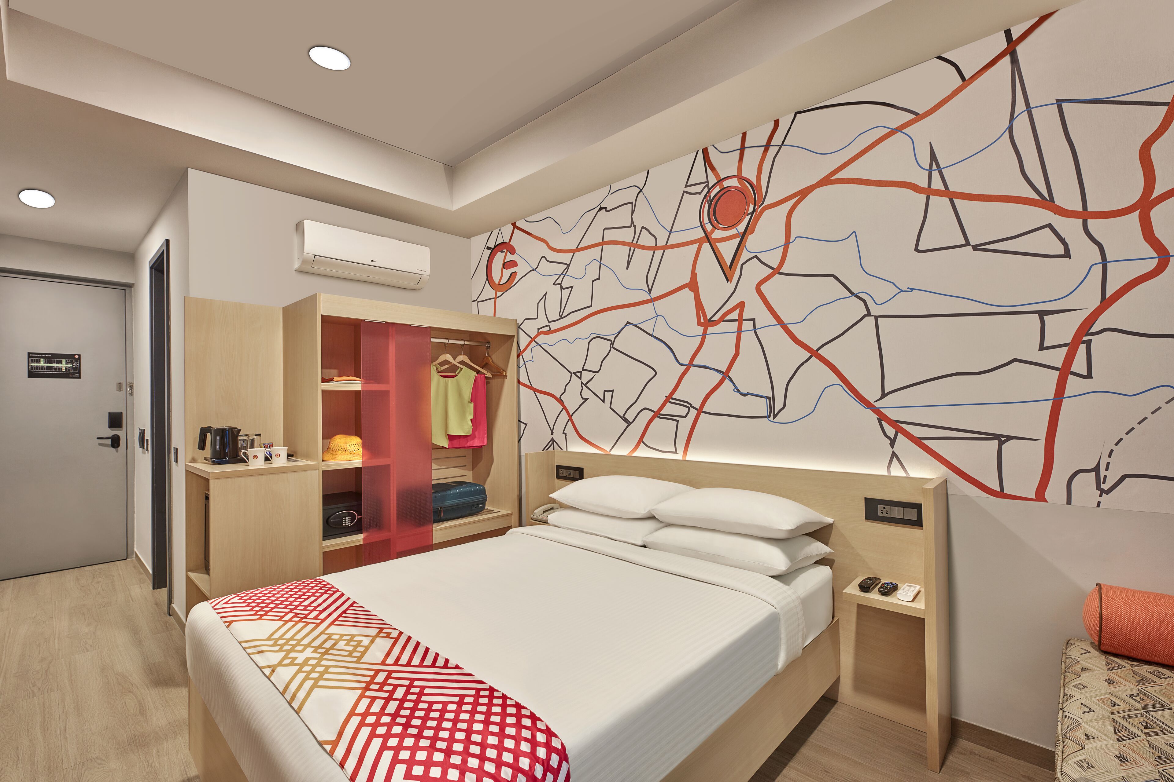 Quarto de hotel moderno com uma cama grande, um guarda-roupa, uma mesa de cabeceira e um mapa de parede.