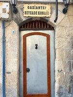 Uma porta com uma placa acima que diz 'GAZIANTEP BEYZADE KONAGI'.