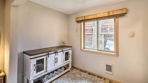 Quarto com um armário de madeira, uma janela com persianas e uma luminária no teto.