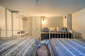 Quarto com duas camas, um guarda-roupa e espaço para pendurar roupas.
