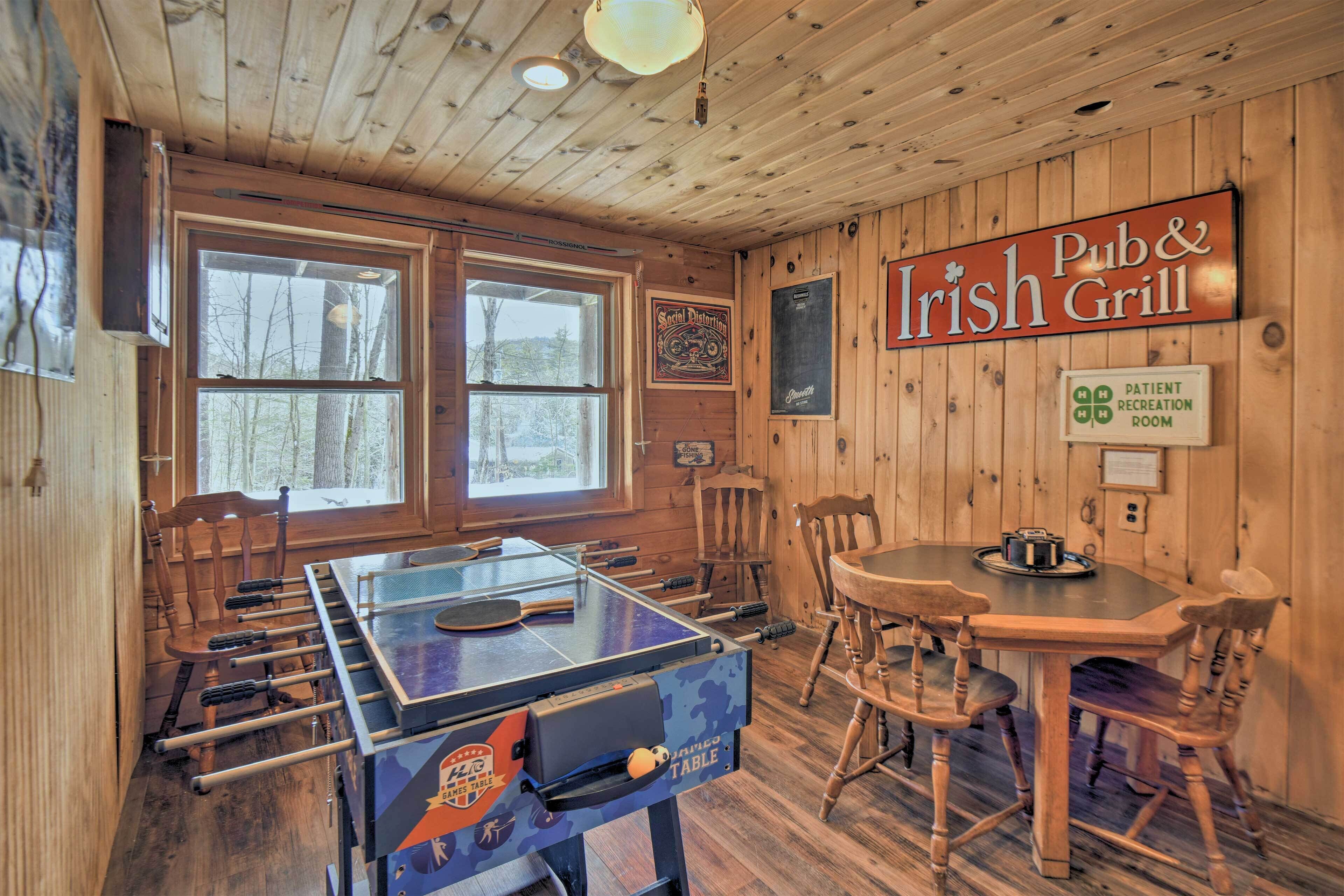 Interior de madeira com mesa de futebol, cadeiras de madeira, uma mesa com jarra e placa indicando 'Irish Pub & Grill'.