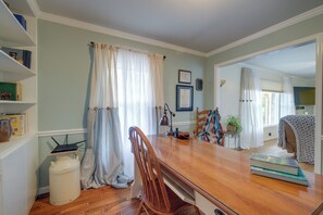 Uma sala de jantar com mesa de madeira, cadeiras e cilindro de gás branco.
