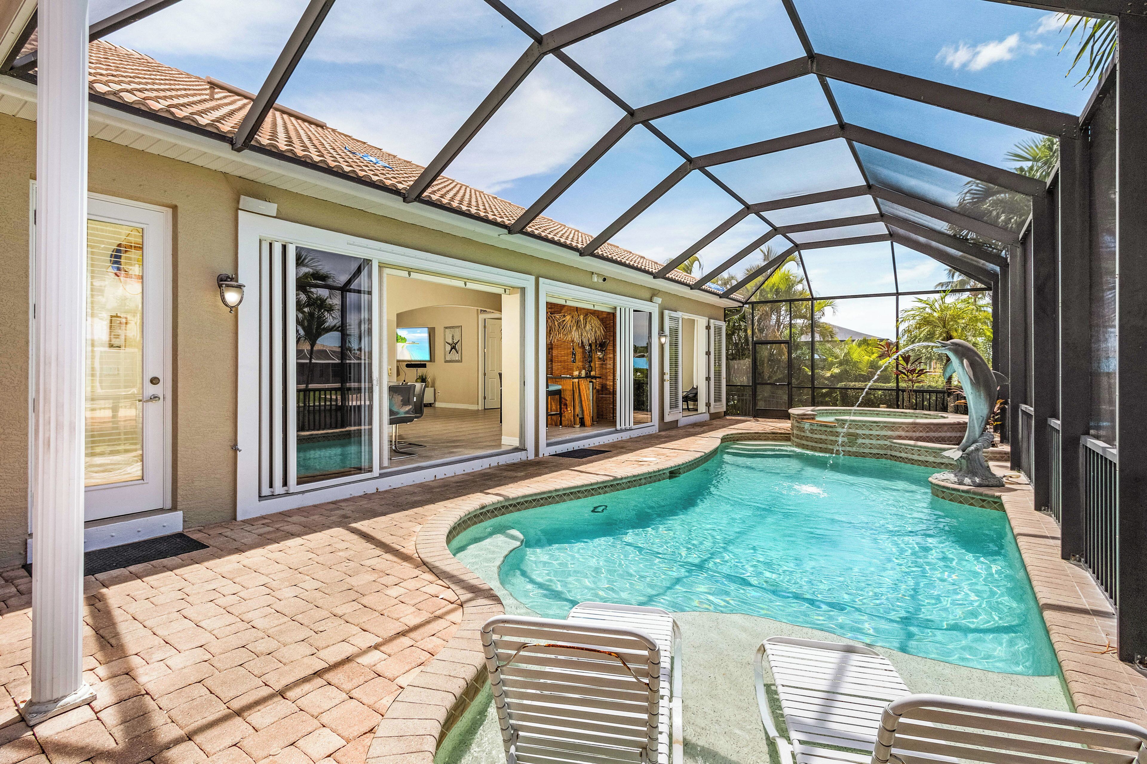 Piscina coberta com teto de vidro, um terraço de tijolos e vista para o exterior.