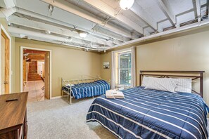 Quarto com uma cama grande, uma escrivaninha e uma janela.