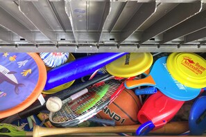 Uma máquina de lavar louça cheia de diversos equipamentos esportivos e utensílios de cozinha.