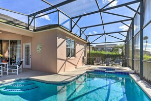 Piscina com cobertura de vidro, alpendre coberto e área de estar externa.