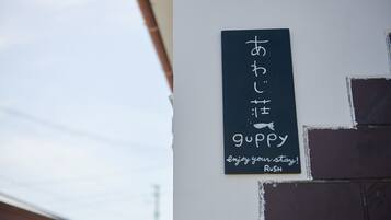Um letreiro na parede com caracteres japoneses e a palavra 'goppy' escrita abaixo.