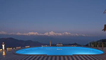 Piscina com vista para montanhas cobertas de neve ao fundo.
