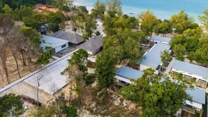 Uma área costeira com casas e um cais que se projeta para o mar.