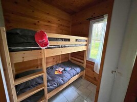 Quarto com beliche, janela e porta.