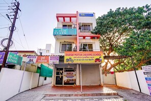 Um edifício com vários andares e diversos estabelecimentos comerciais, incluindo um hotel, uma escola de motoristas e um restaurante.