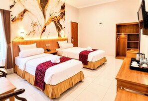 Quarto de hotel com duas camas, cabeceira de madeira, televisão, escrivaninha com bandeja de amenidades e parede de mármore.
