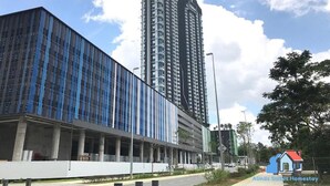 Um edifício moderno com fachada de vidro e um arranha-céu alto ao lado.