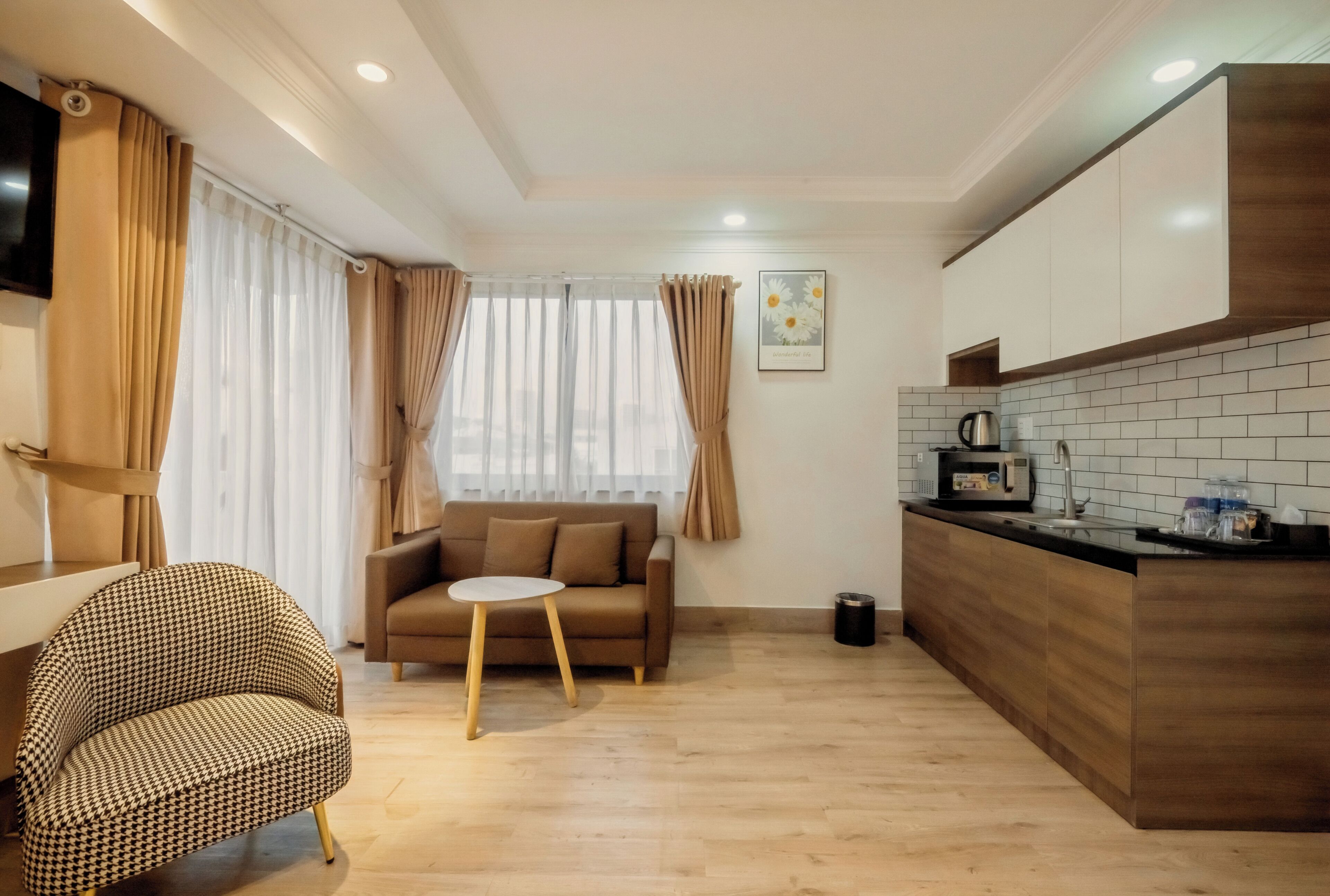 Uma sala de estar moderna com um sofá, uma mesa redonda pequena e uma poltrona xadrez.