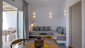 Quarto moderno com mesa de jantar de madeira, um sofá e porta de vidro para uma varanda.