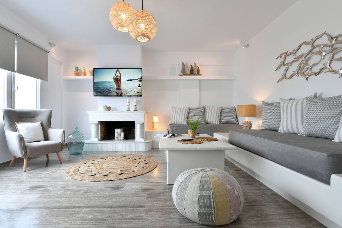 Uma sala de estar moderna com lareira, um sofá e uma televisão.