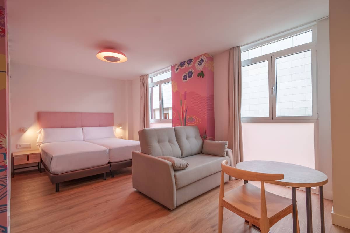 Quarto com sofá, uma mesinha e cama.