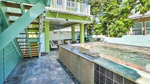 Uma área externa com vários níveis, piscina, escada e um espaço coberto para sentar.