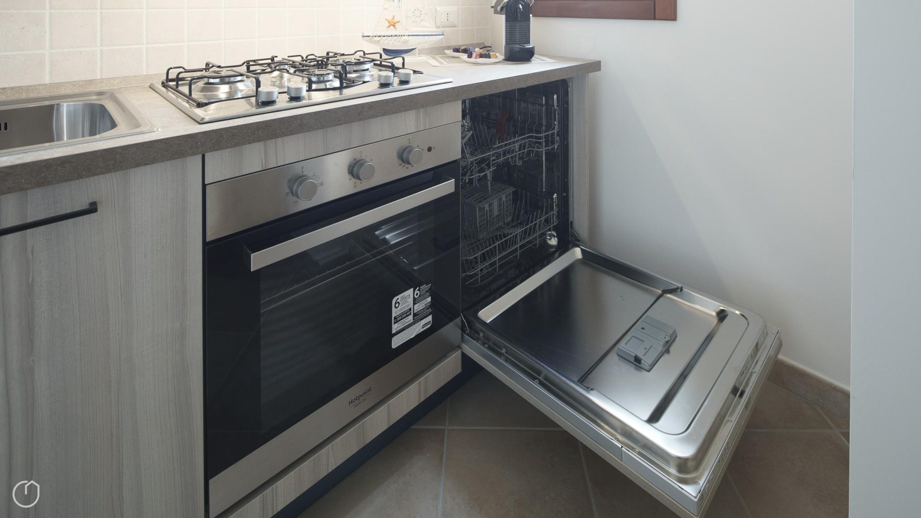 Uma cozinha compacta com fogão a gás, forno e lava-louças.