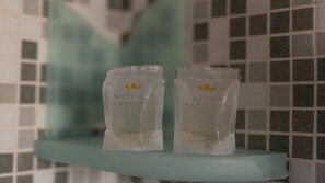 Duas garrafas de shampoo Natural Sardinia numa prateleira de banheiro.