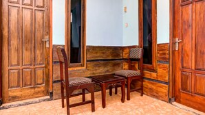 Um quarto de madeira com chão de azulejos, uma mesa de madeira e duas cadeiras.