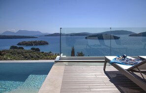 Área à beira da piscina com vista clara para o mar e ilhas.