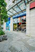 Uma cafeteria com fachada de vidro e um letreiro que diz 'Wayne's Coffee'.