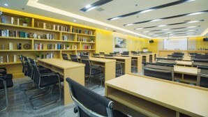 Uma biblioteca moderna com estantes, mesas e cadeiras dispostas para leitura e estudo.