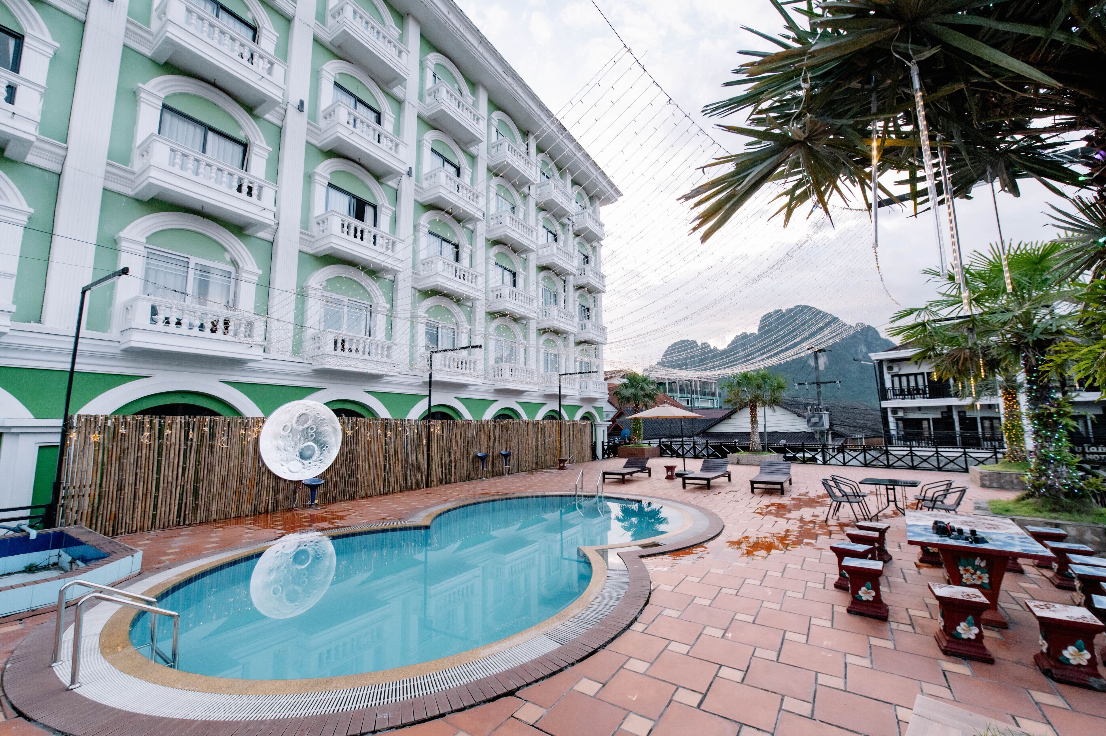 Um hotel com piscina, área de estar externa e vista para montanhas.