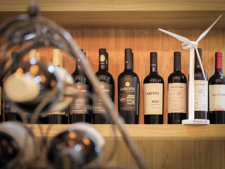Uma adega com garrafas rotuladas 'Laretis' e 'Salvattore', com um fundo de madeira.