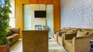 Uma sala de estar moderna com um sofá, uma mesa de centro e uma televisão na parede.